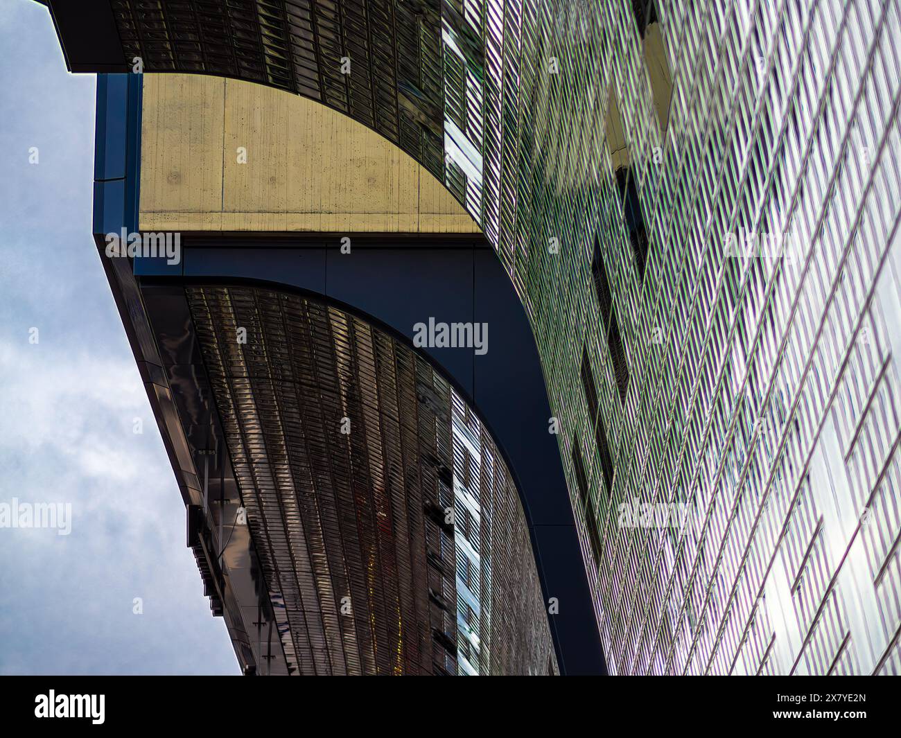 A modern architectural marvel with a curved, reflective glass facade ...