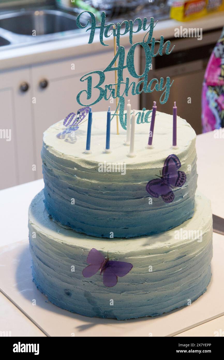 40th birthday cake, 2 levels in blue and white frosting with candles on ...