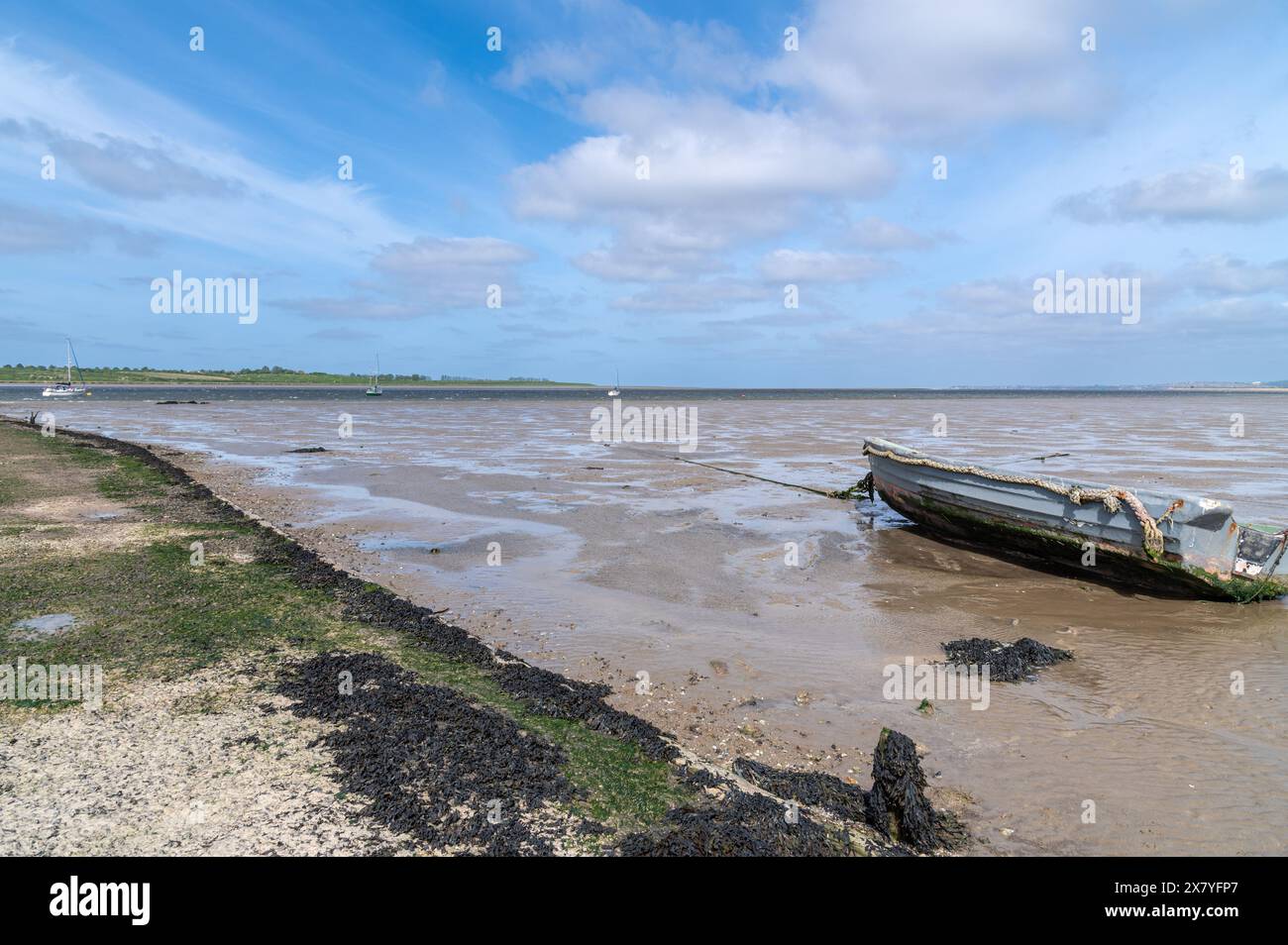 Old grey boat moored near the causeway to the Isle of Sheppey, Kent ...