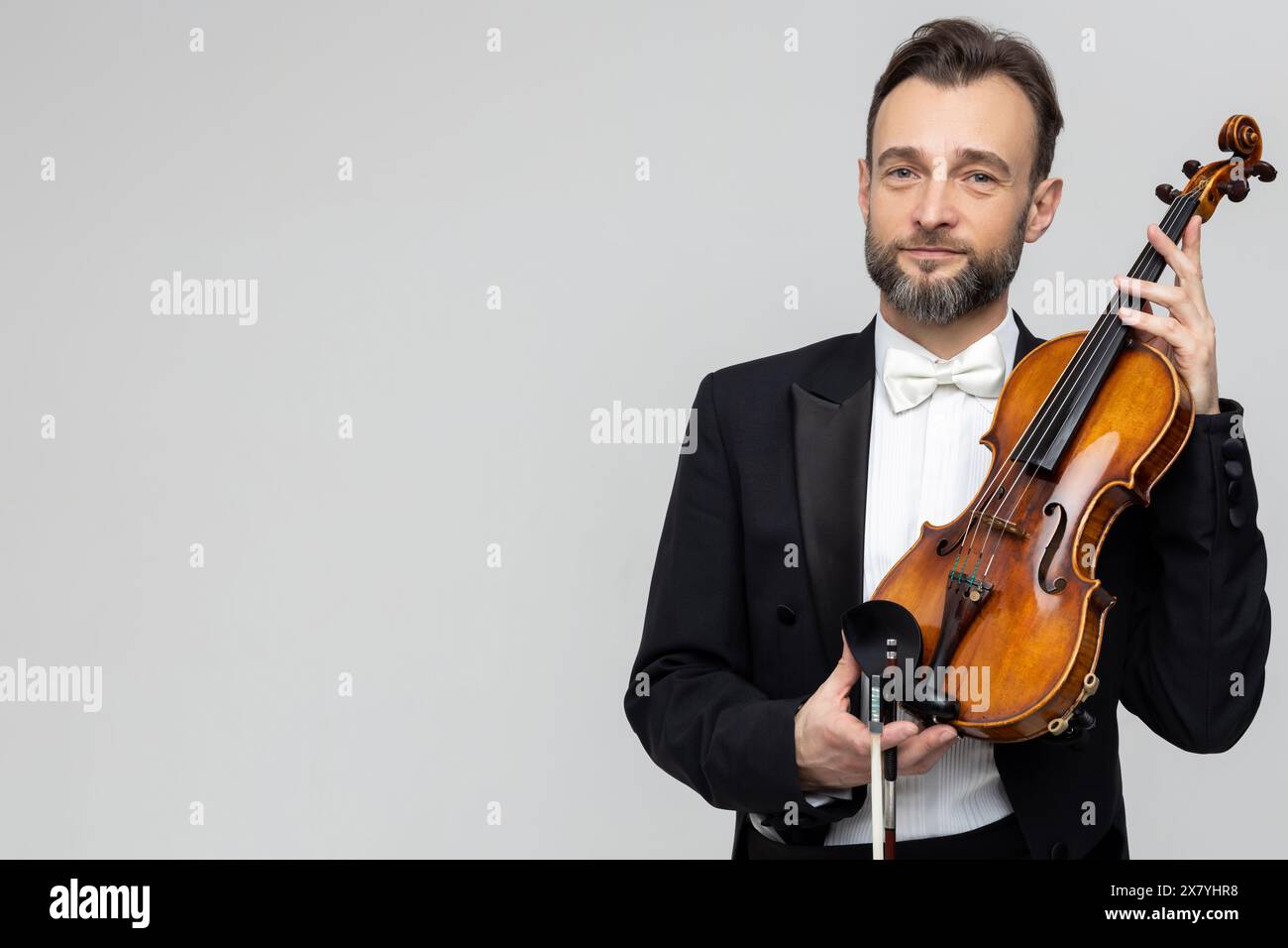 Classical musician holding violin Stock Photo - Alamy