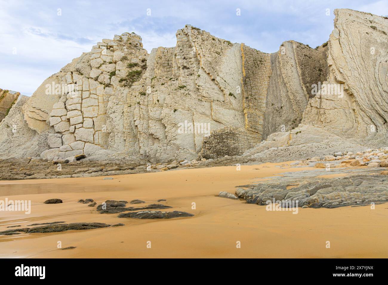 Portio Beach with its golden sand, layers of rock eroded since the ...