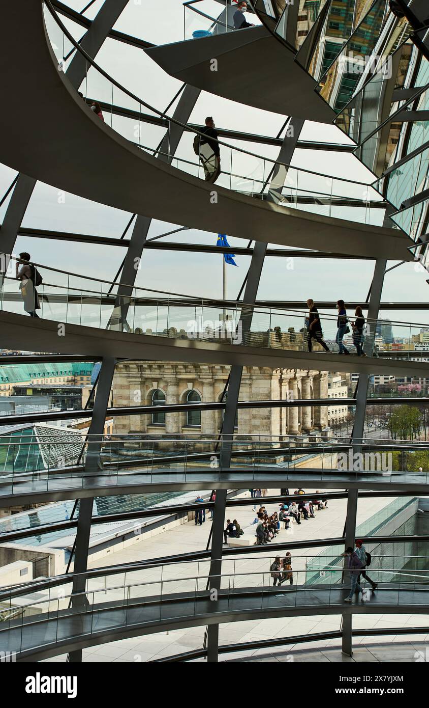 People walking in the modern glazed dome of the Reichstag building in ...