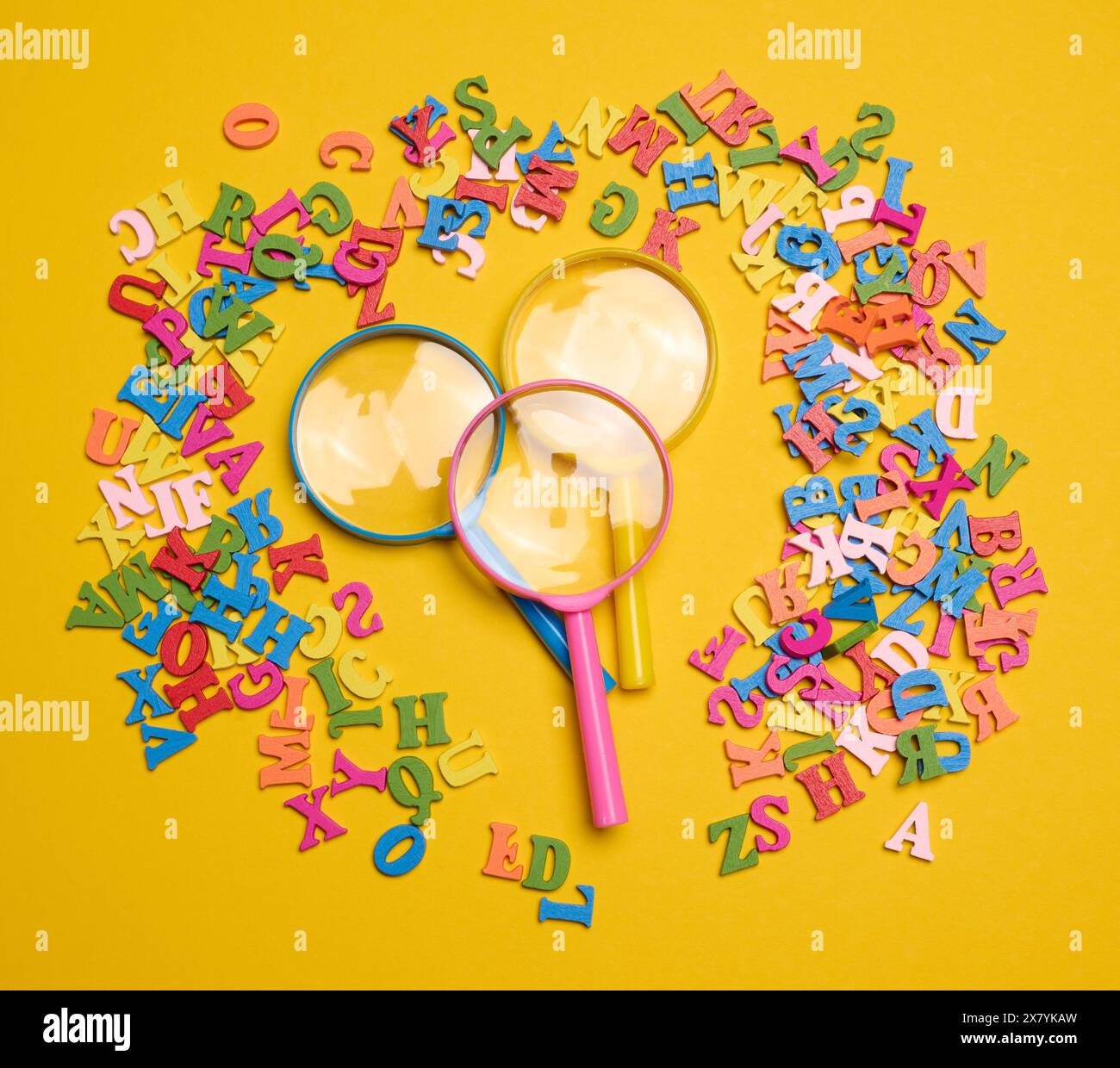 Plastic magnifying glass and wooden letters of the English alphabet on ...