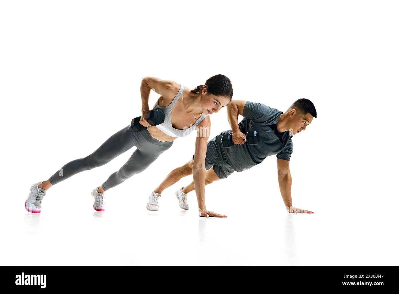 Dynamic image of fit man and woman performing plank row exercise with ...