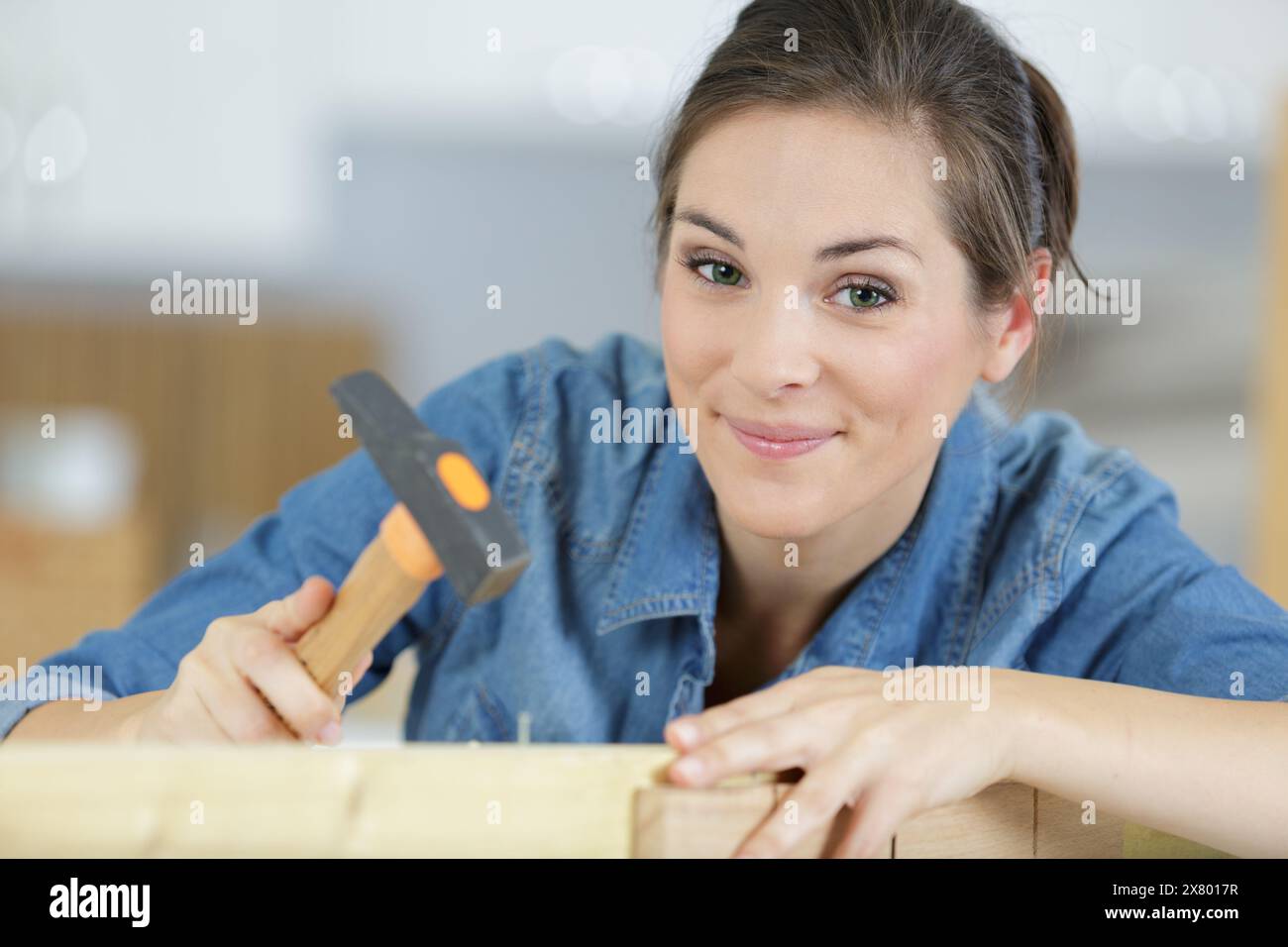 pretty female using wood hammer for wood Stock Photo - Alamy