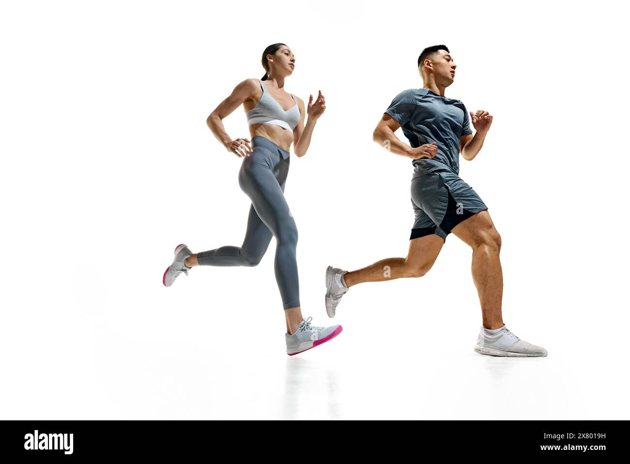 Two athletes sprinting, captured in moment of peak effort against white ...