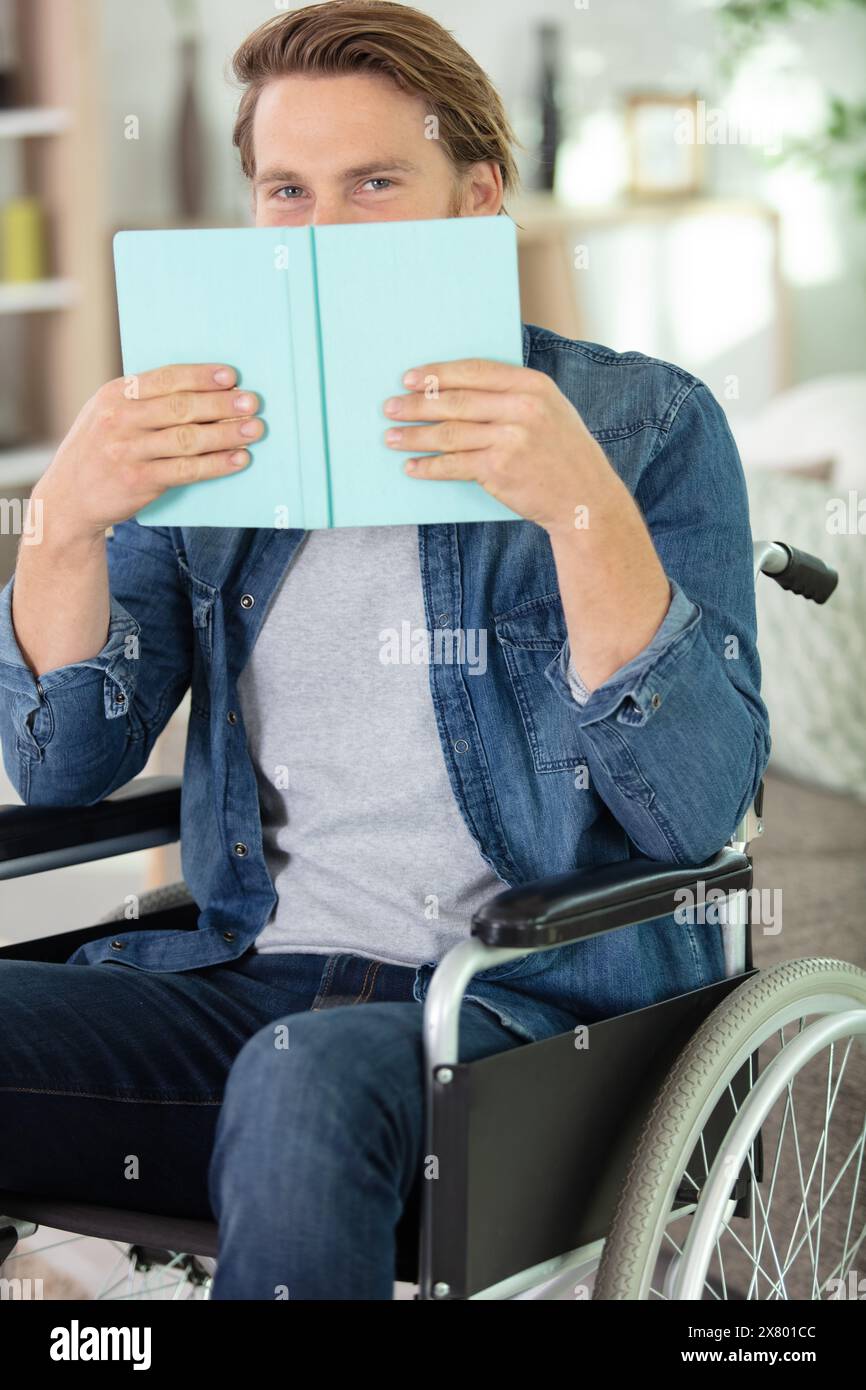 young handsome handicaped man reading at home Stock Photo - Alamy