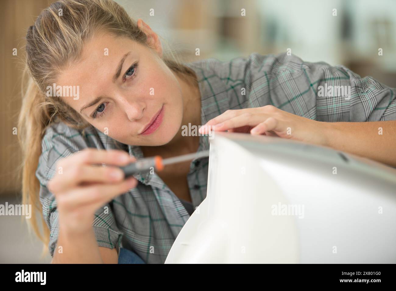 an electrician woman installing heater Stock Photo - Alamy