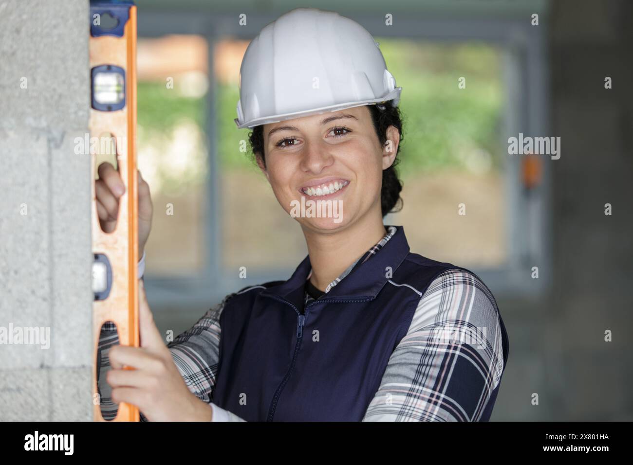 happy female worker using a level tool Stock Photo - Alamy