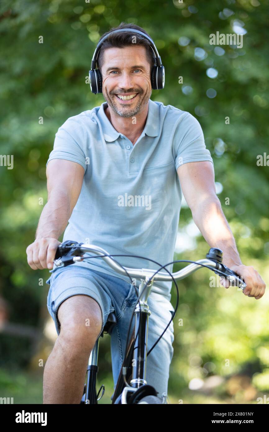 handsome man taking a tour bicycle and smiling Stock Photo - Alamy