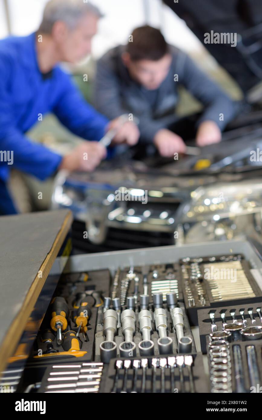 mechanic tools at garage with mechanics in the background Stock Photo ...