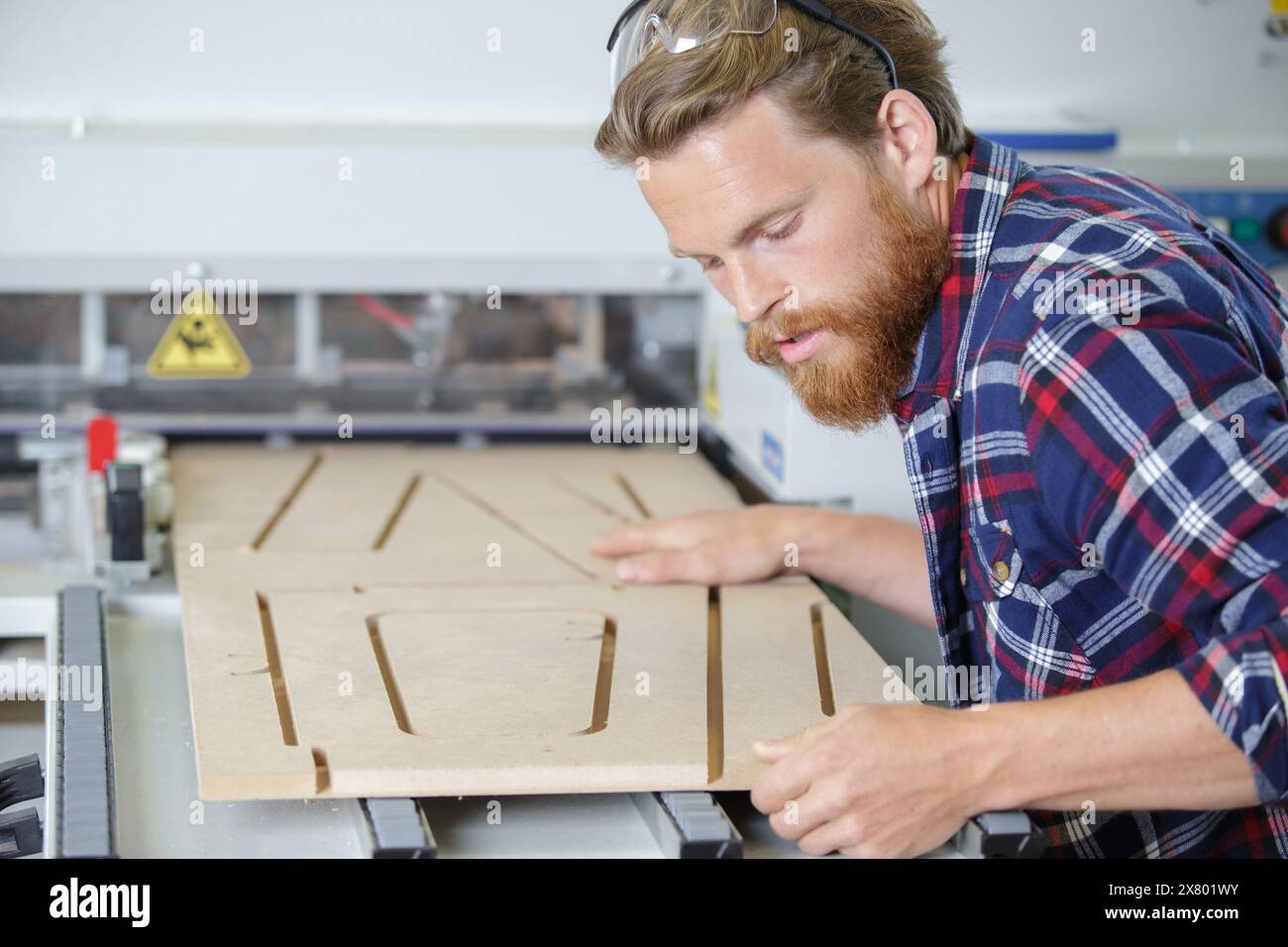 male worker cutting wood shapes Stock Photo - Alamy