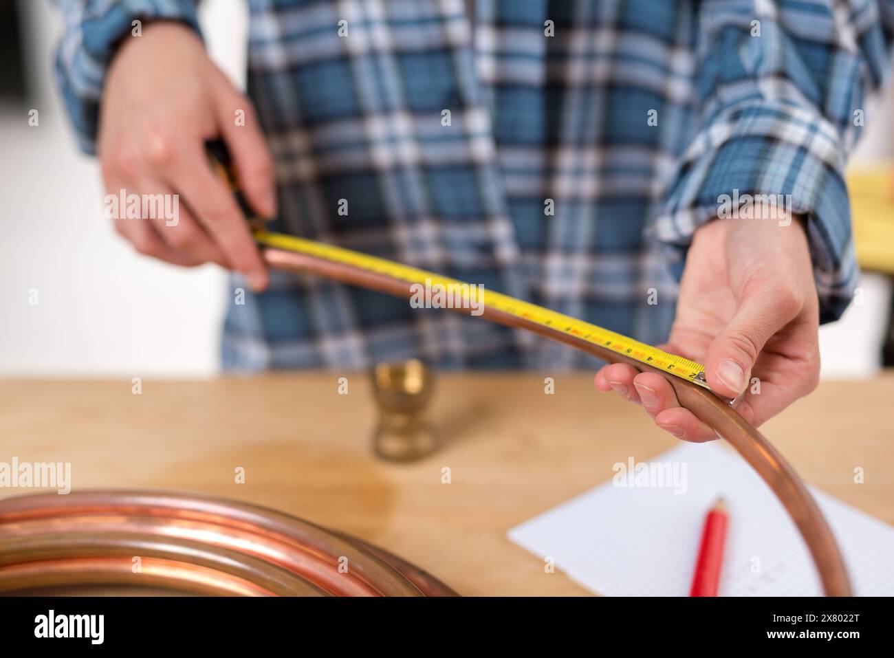 portrait of man measuring cooper pipes Stock Photo - Alamy