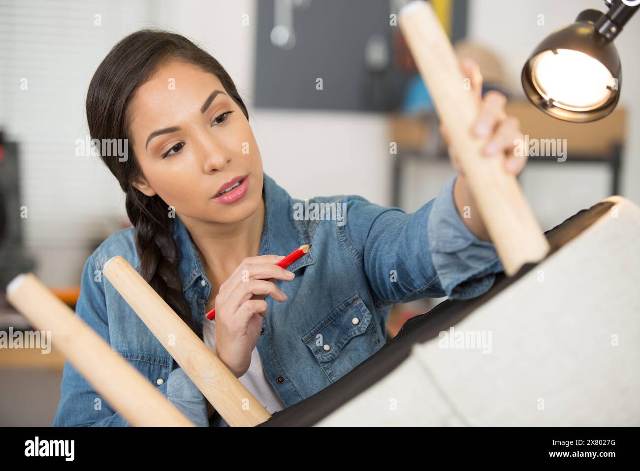 female furniture worker measuring chair leg Stock Photo - Alamy