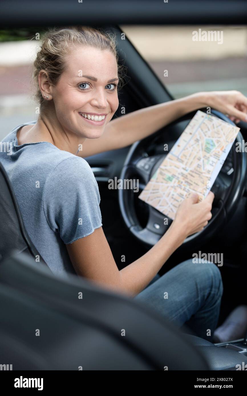 woman in her car holding a paper map Stock Photo - Alamy