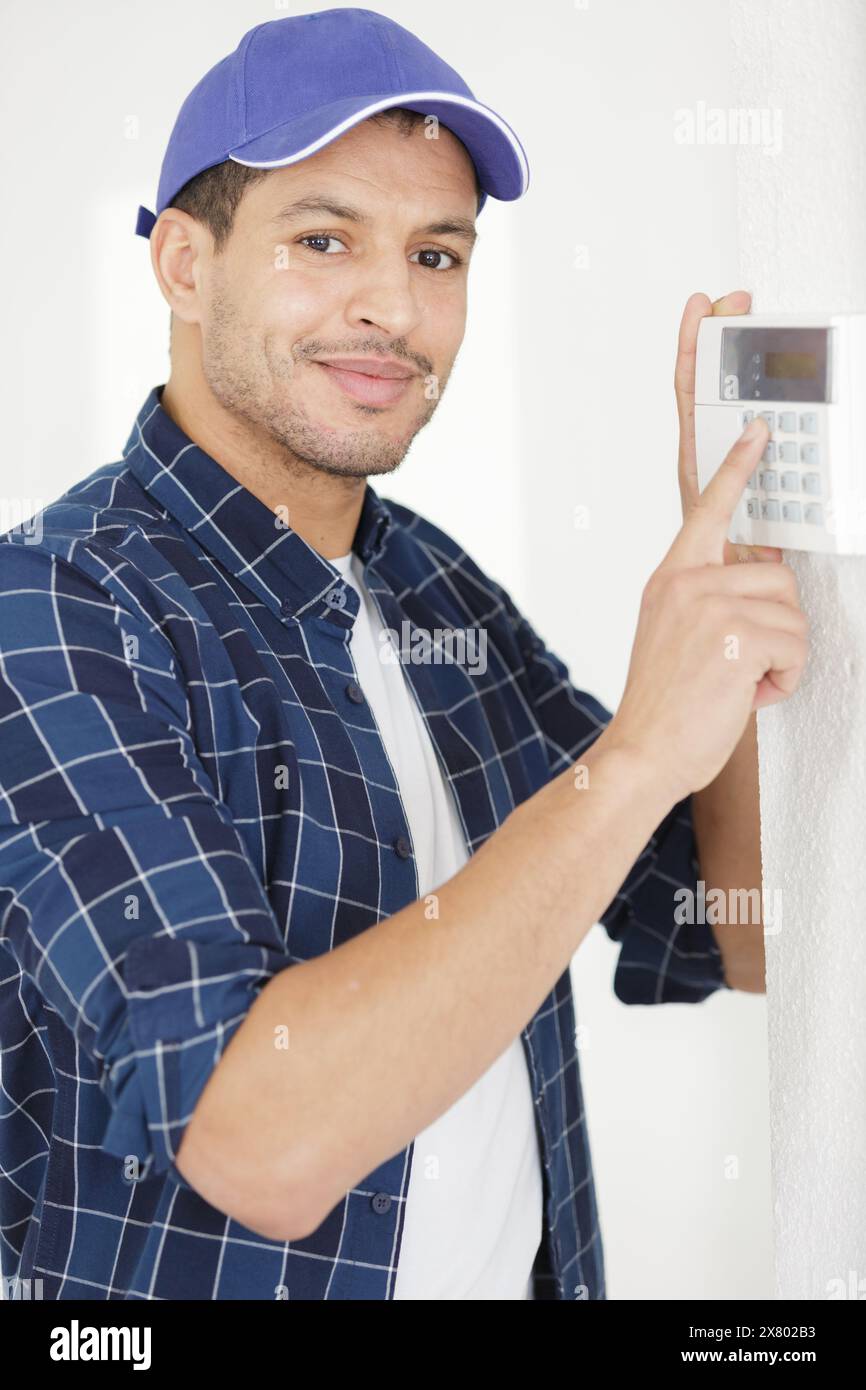 male electrician installing security system door Stock Photo - Alamy