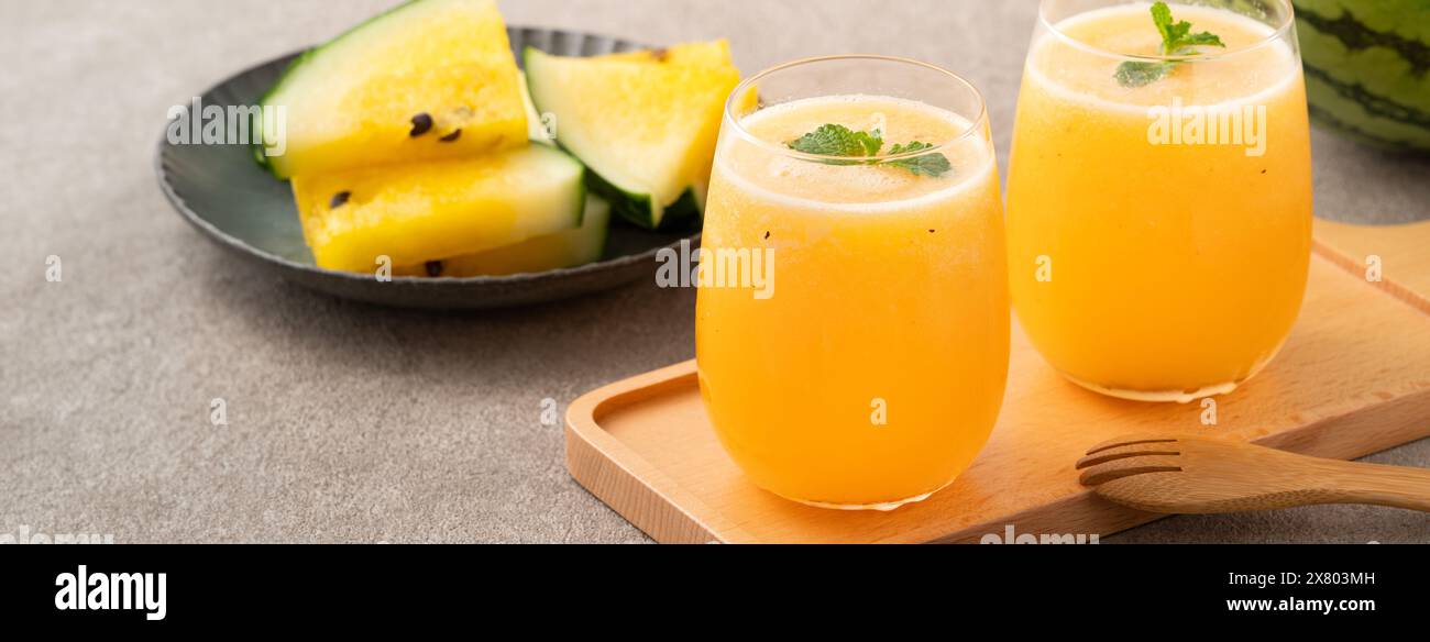 Fresh yellow watermelon juice cold drink in a glass cup with sliced ...