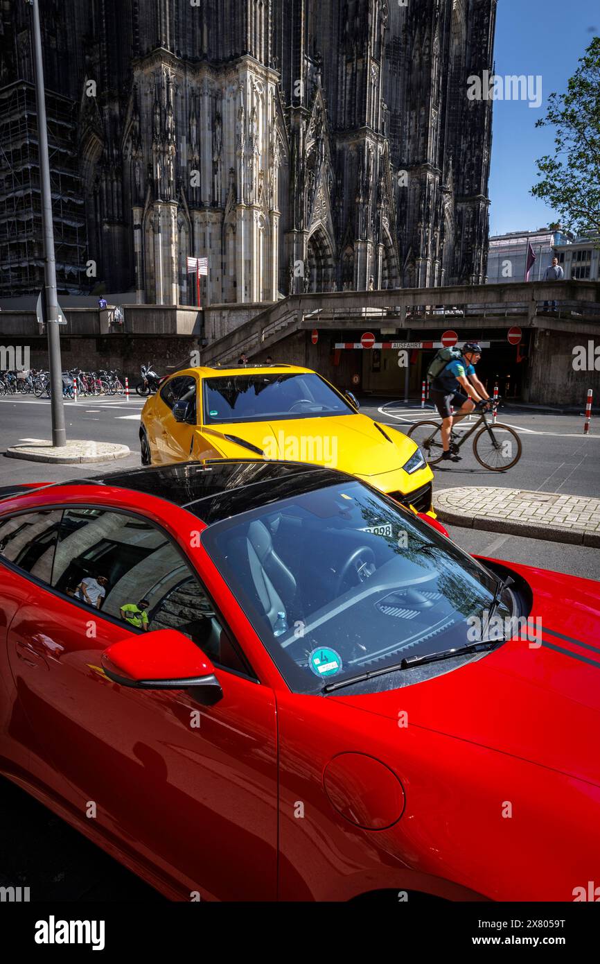 a Porsche 911 and a Lamborghini Urus stand in front of the of the ...