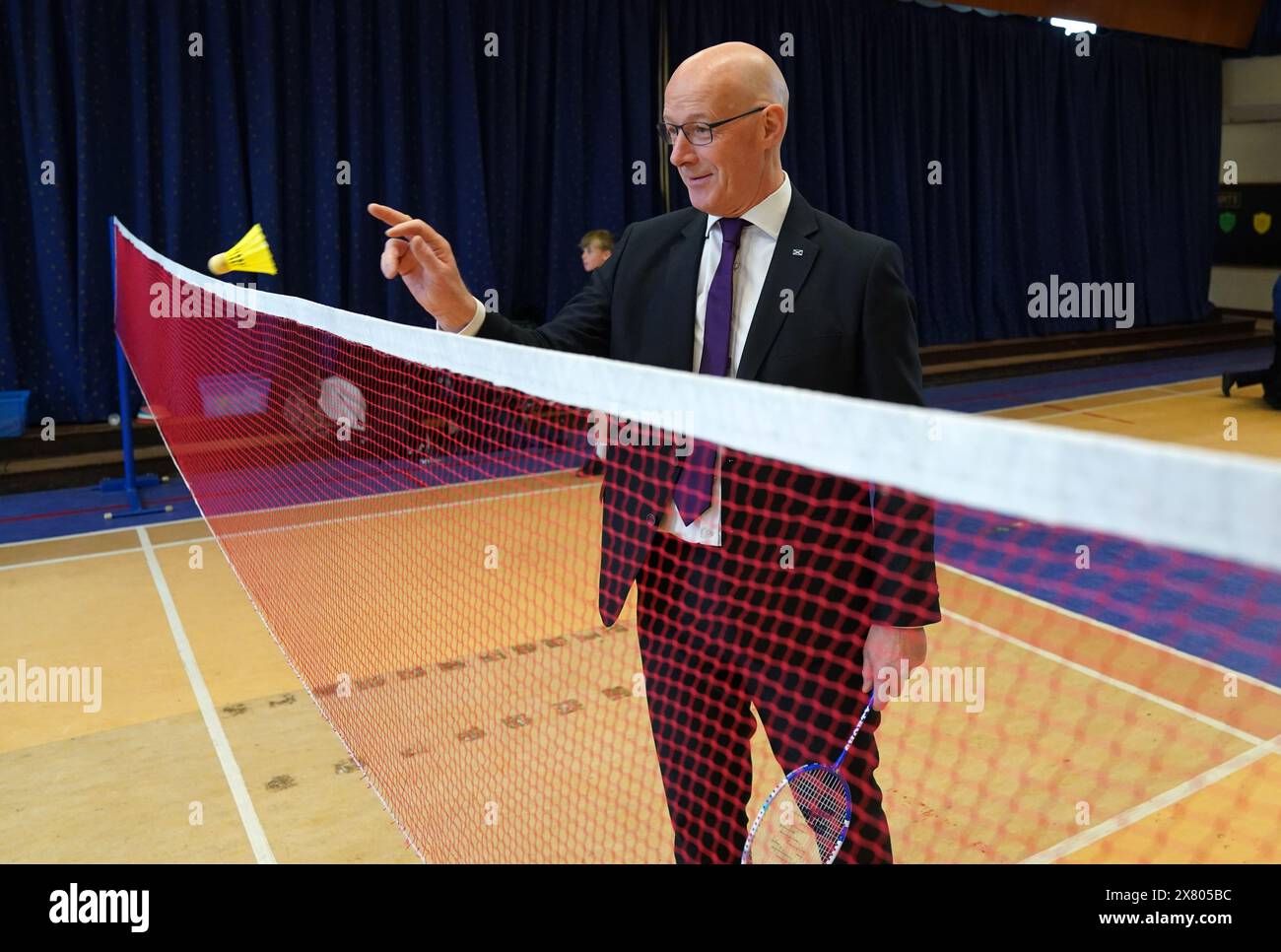 First Minister John Swinney plays badminton with pupils during a visit ...