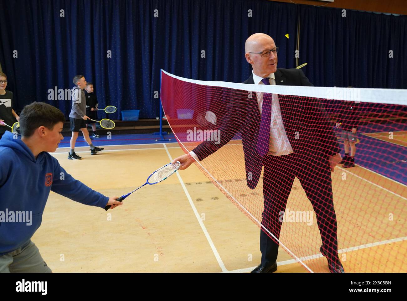 First Minister John Swinney plays badminton with pupils during a visit ...