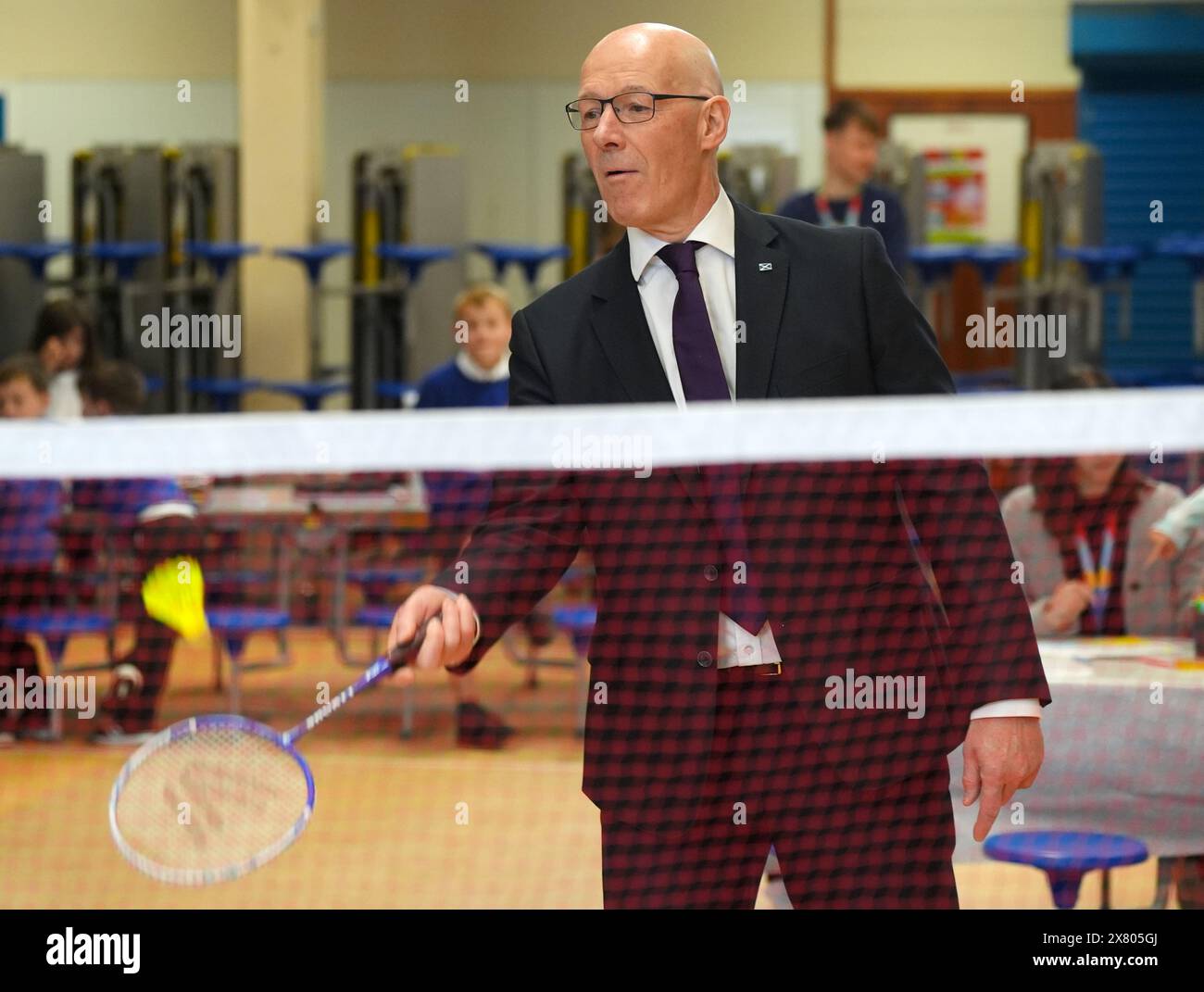 First Minister John Swinney plays badminton with pupils during a visit ...