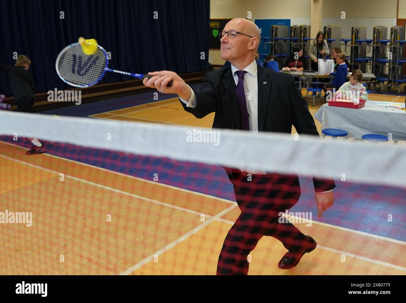 First Minister John Swinney plays badminton with pupils during a visit ...