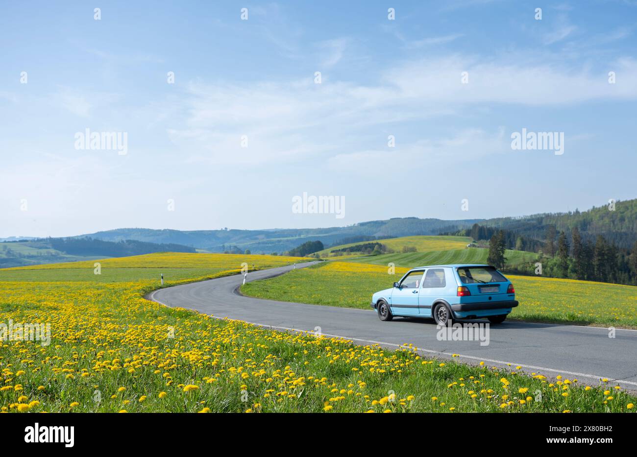 blue car under blue sky in spring countryside of german sauerland with ...