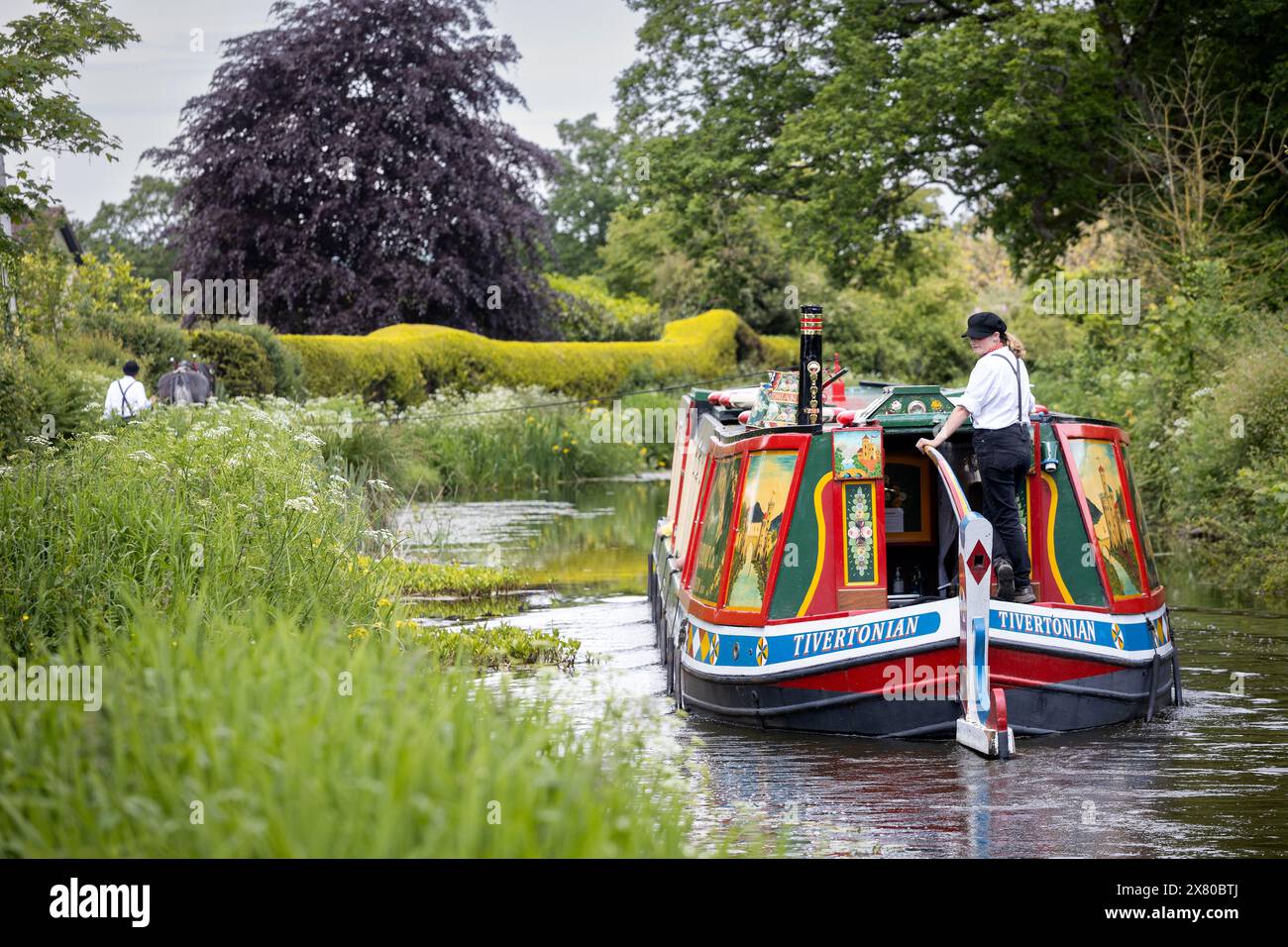 The barge glides along the Grand Western Canal in Tiverton, devon, to provide a seren scene. the ...