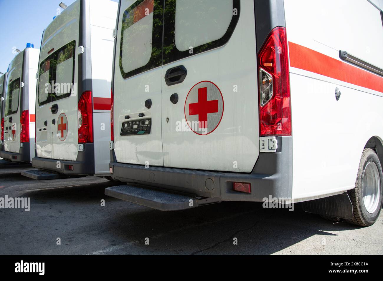 A row of rescuers cars. Side view of an ambulances standing in parking ...