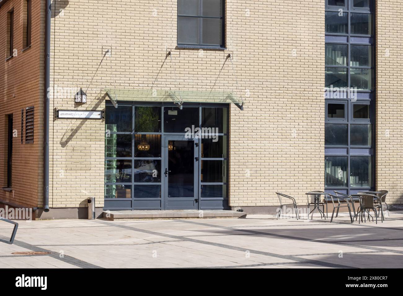 A brick building prominently displays the letter r on its facade ...