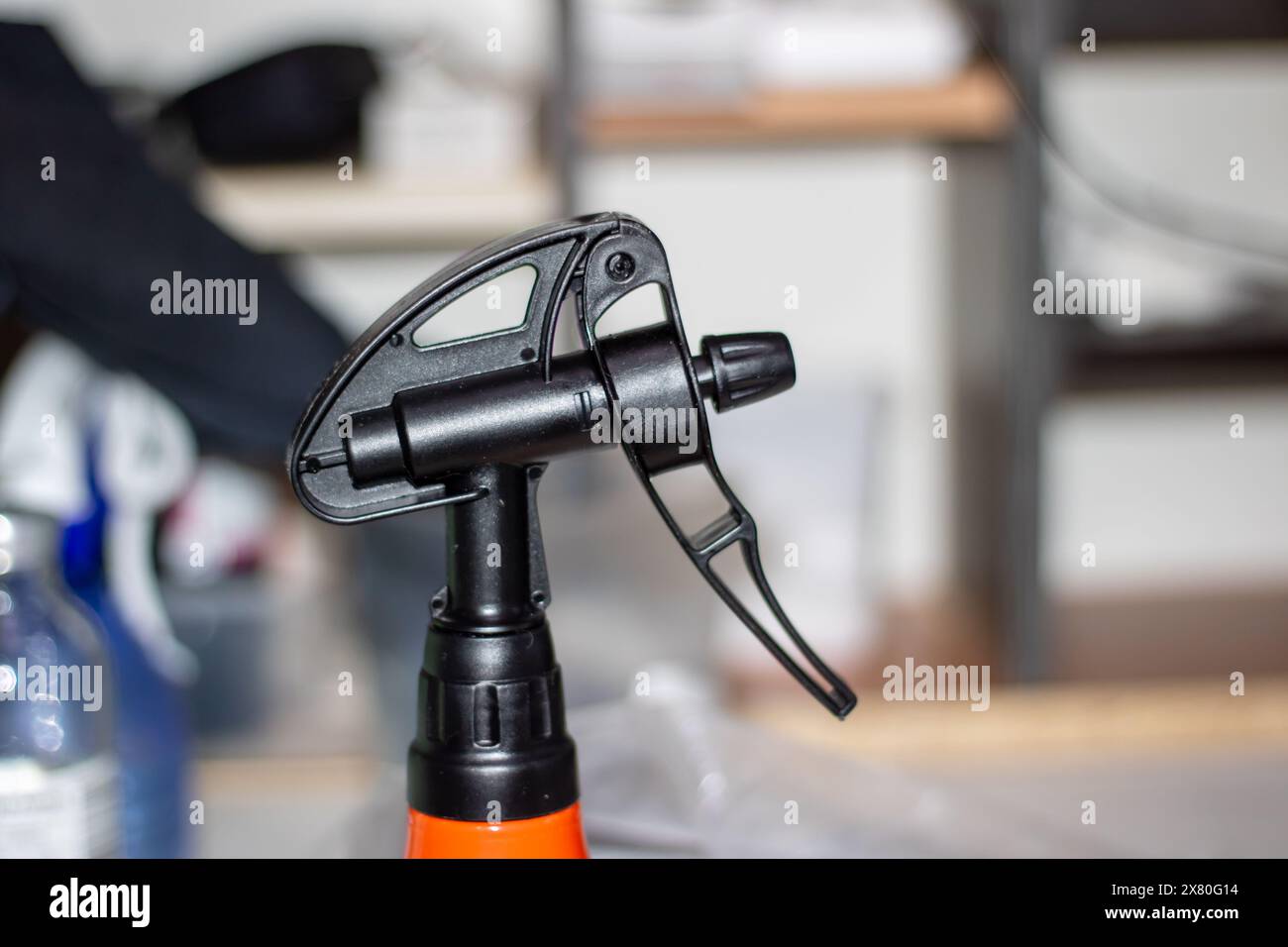 In the closeup image, a spray bottle is clearly displayed on a table ...
