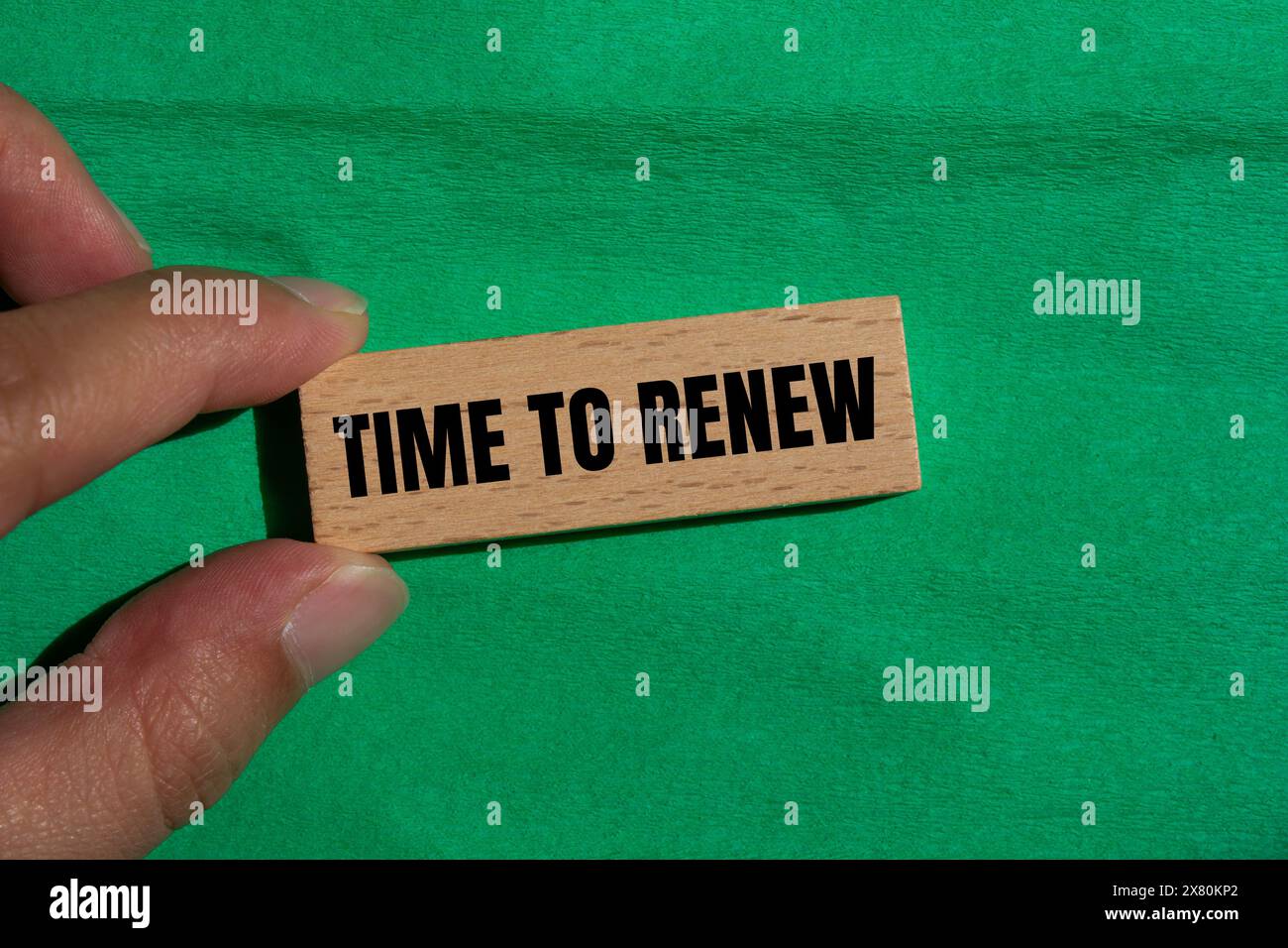 Time to renew words written on wooden block with green background ...