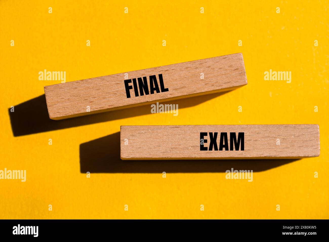 Final exam words written on wooden blocks with yellow background ...