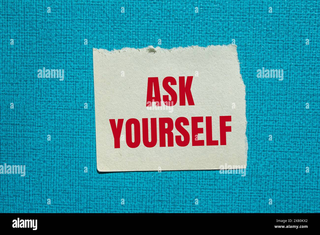 Ask yourself words written on ripped paper with blue background ...