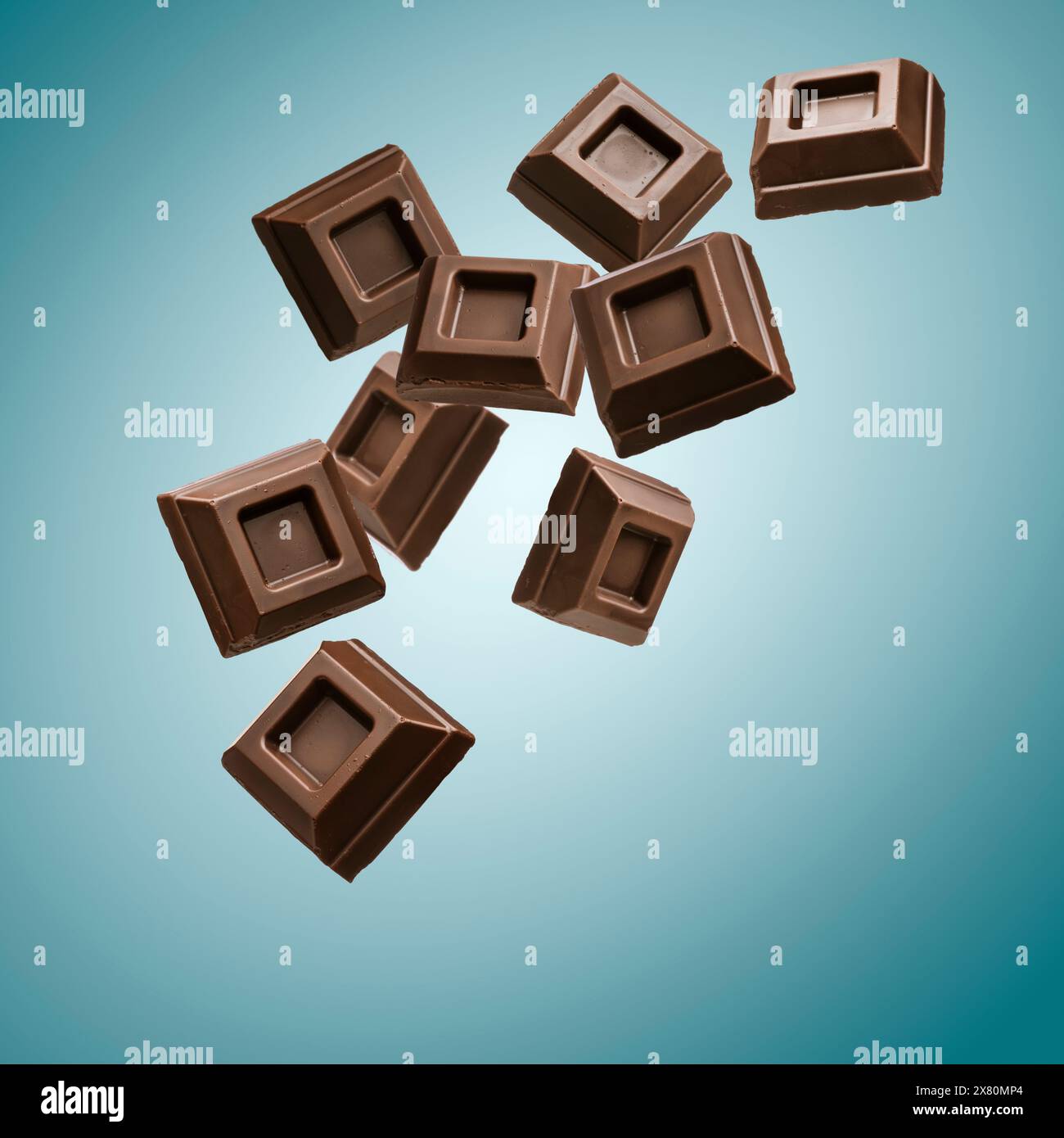 Dark chocolate blocks flying on blue background Stock Photo - Alamy