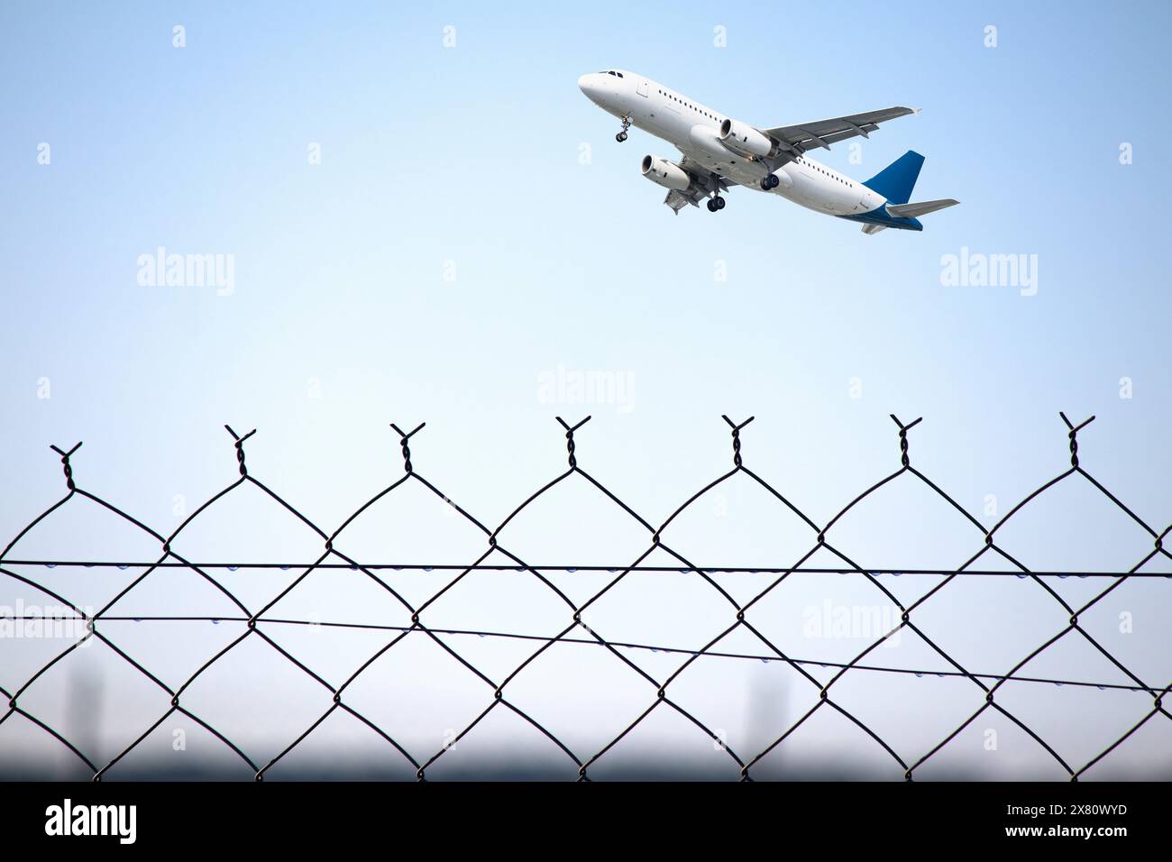 Passenger plane flying behind stainless steel fencing wire. Aviation ...