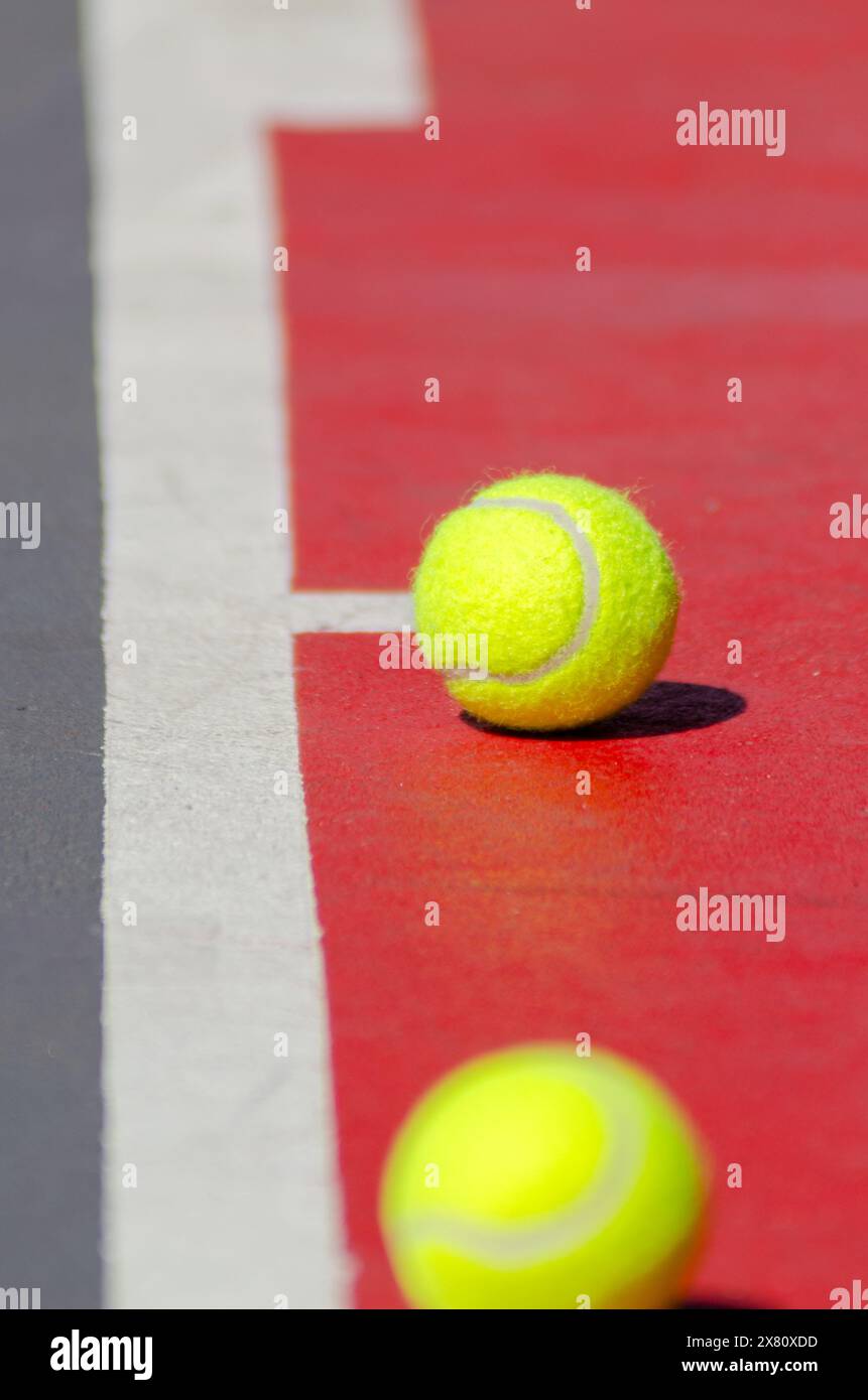 two tennis balls next to the line of a tennis court Stock Photo - Alamy