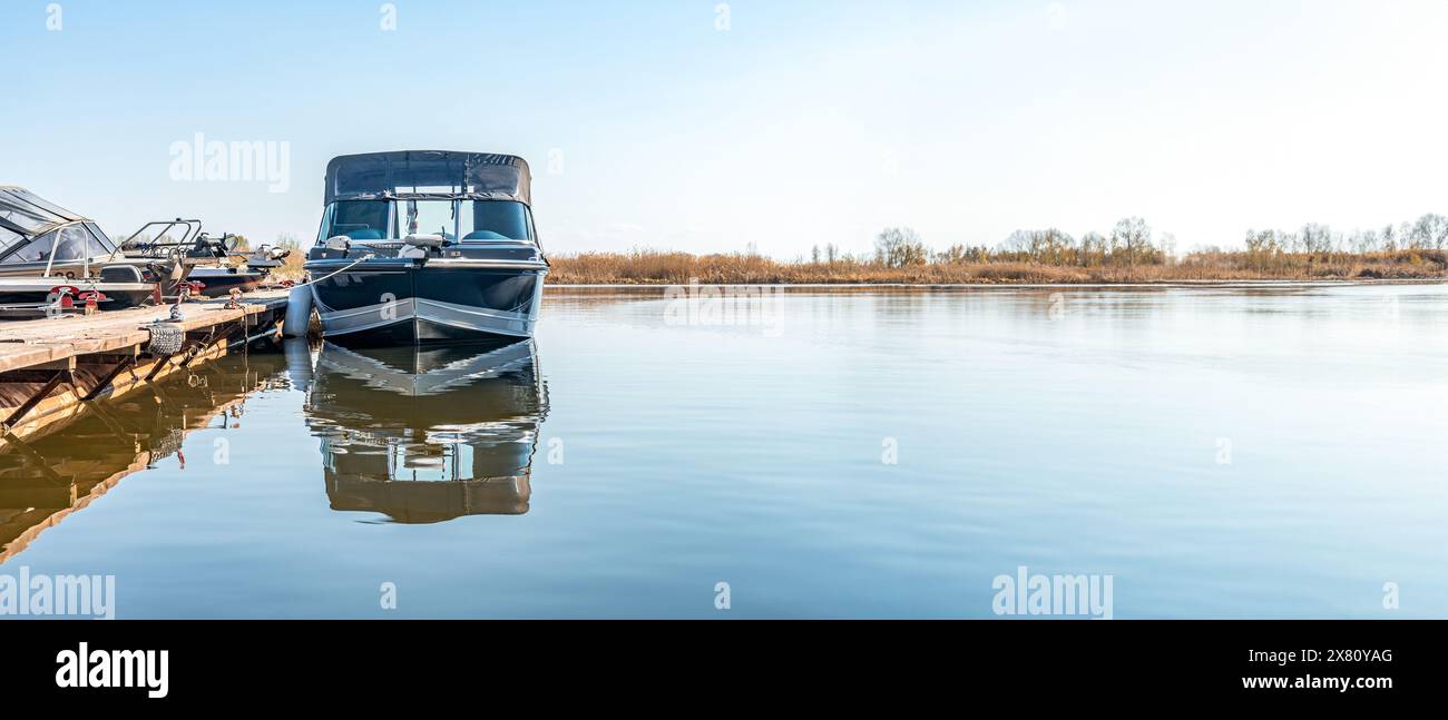 Fishing boats moored at wooden pontoon pier in early morning. Modern ...