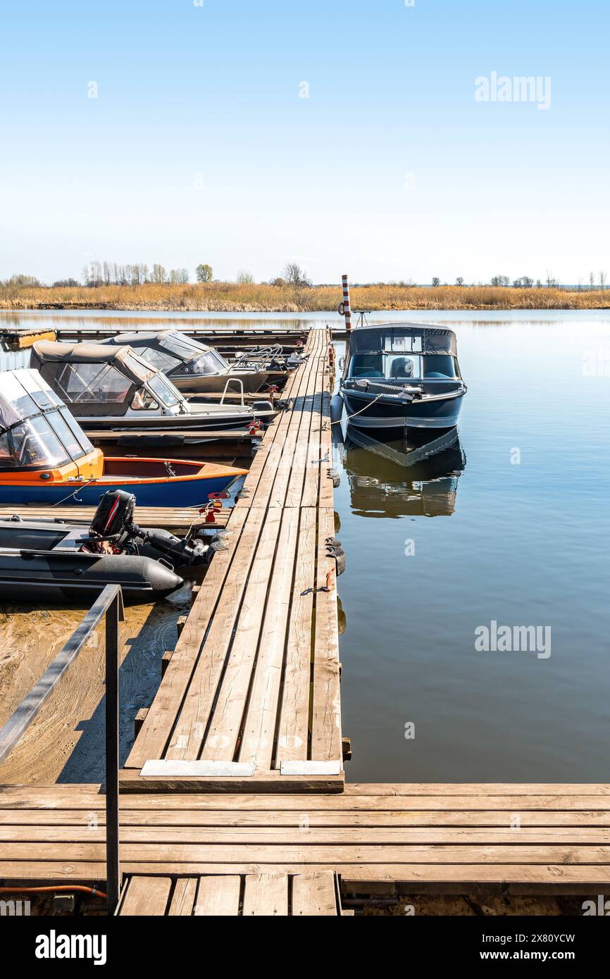 Fishing boats moored at wooden pontoon pier in early morning. Modern ...