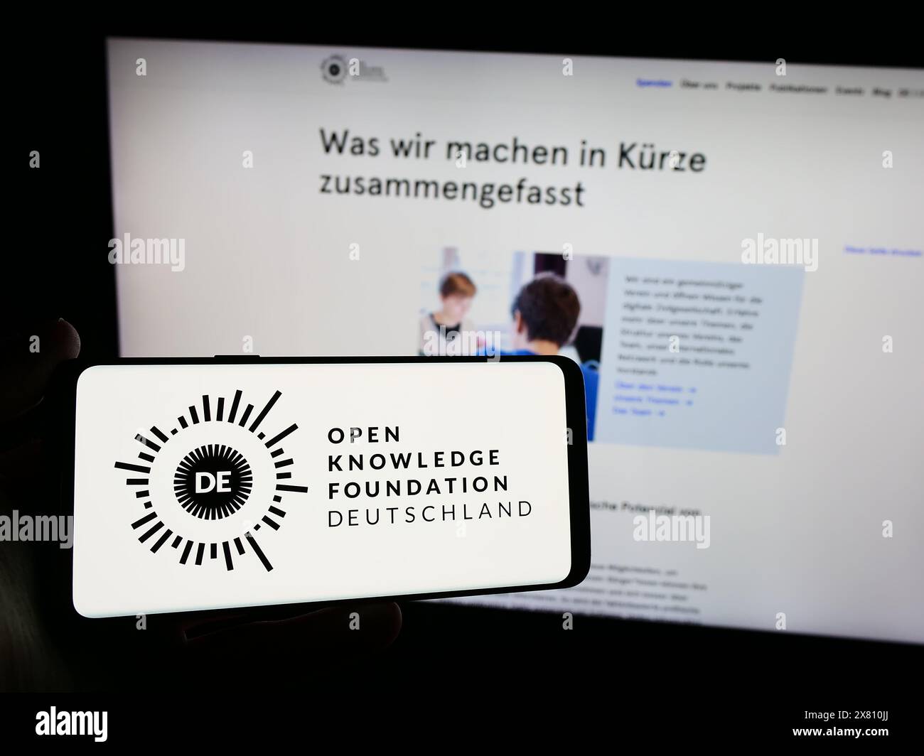 Person holding mobile phone with logo of Open Knowledge Foundation ...