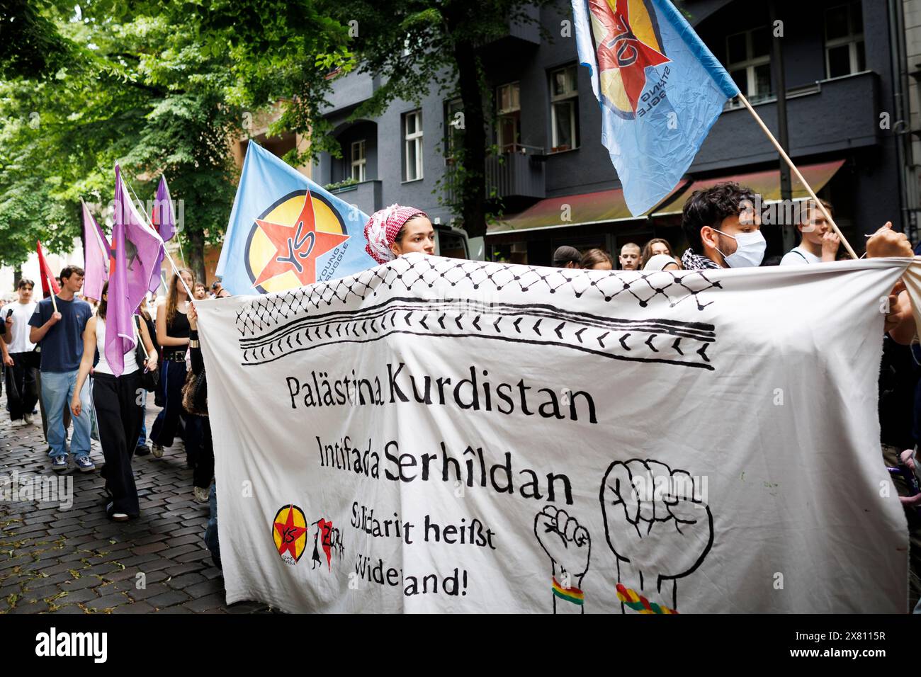 Berlin, Germany. 22nd May, 2024. Participants walk behind a banner with ...