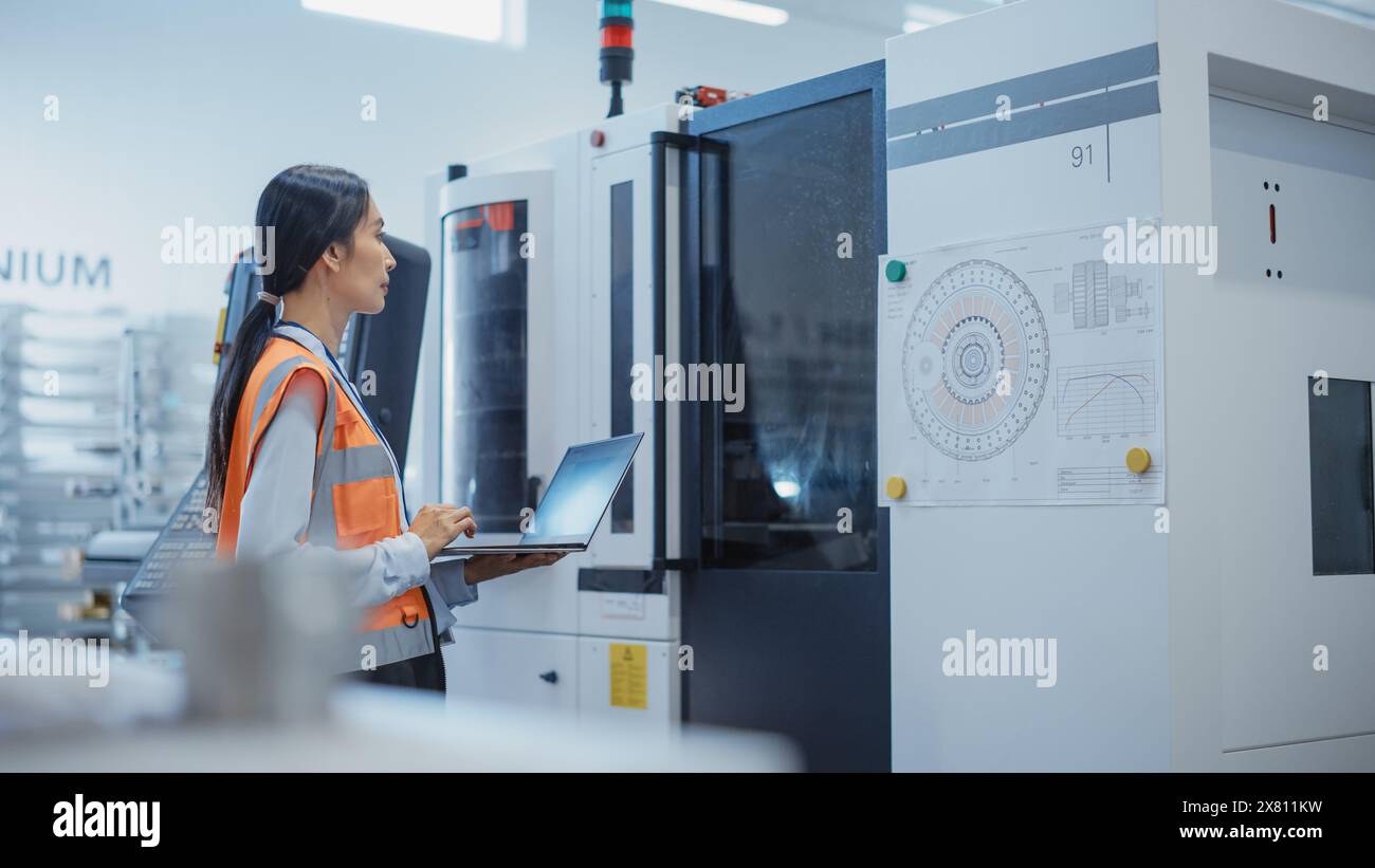 Manufacturing Technician with a Laptop Comes Up to Operate a Heavy ...