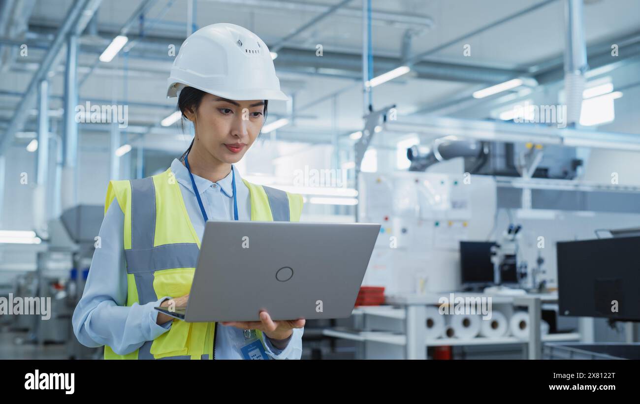 A Focused and Professional Asian Female Engineer in White Hard Hat ...