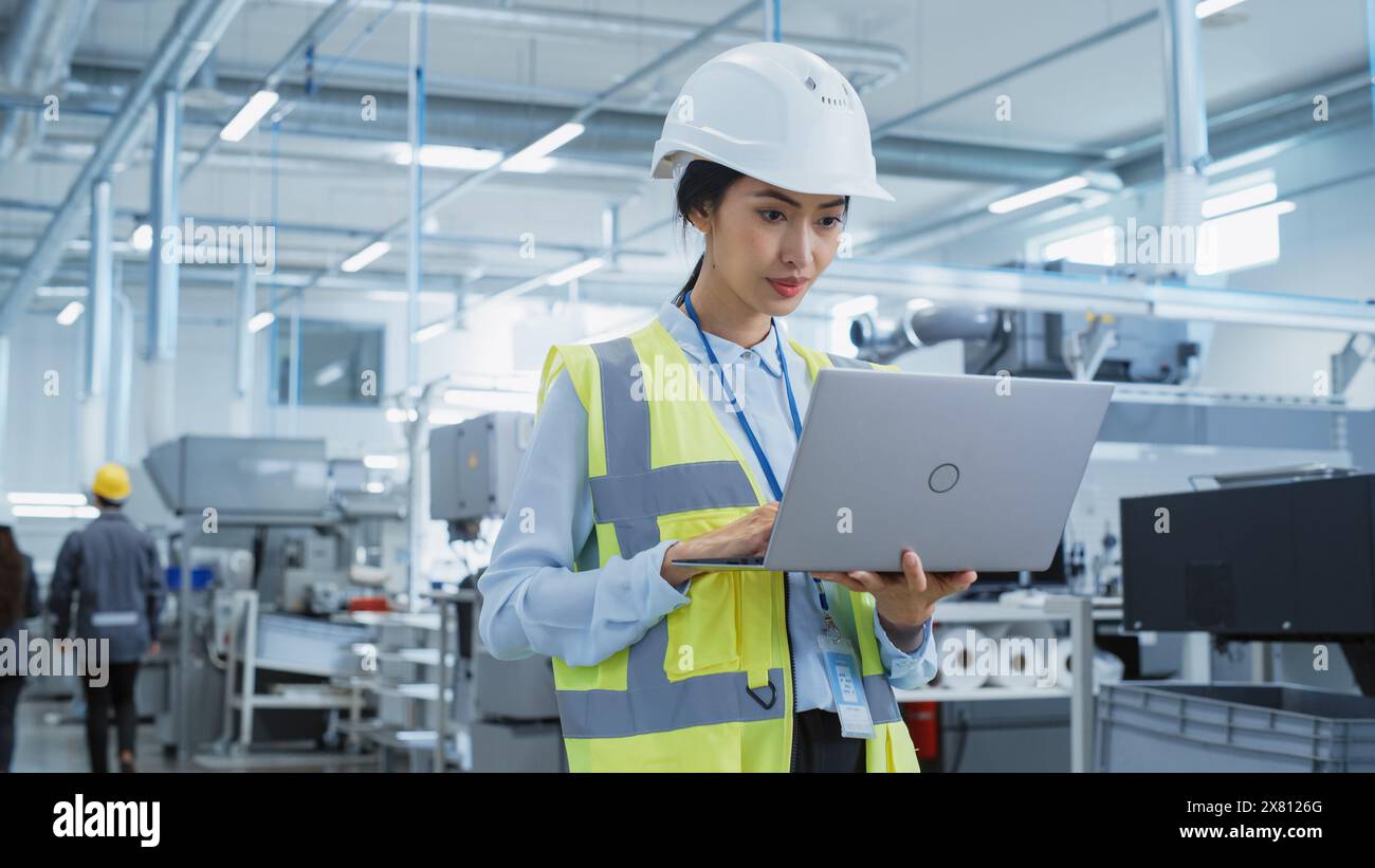 A Focused and Professional Asian Female Engineer in White Hard Hat ...
