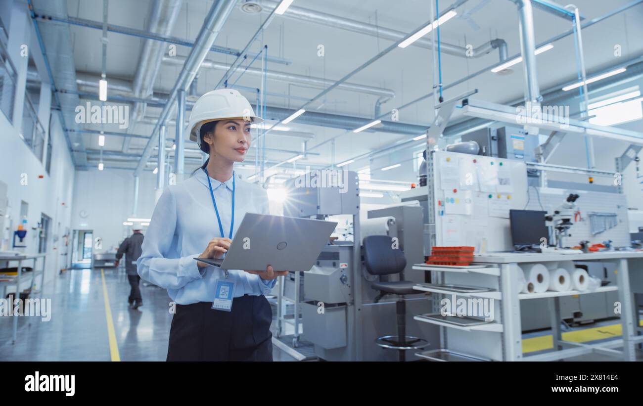 Portrait of an Asian Female Engineer in Hard Hat Walking and Using ...