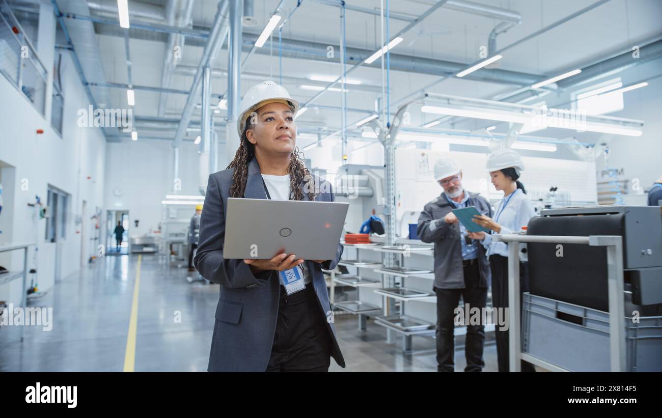 Portrait of an African Female Engineer in Hard Hat Walking and Using ...