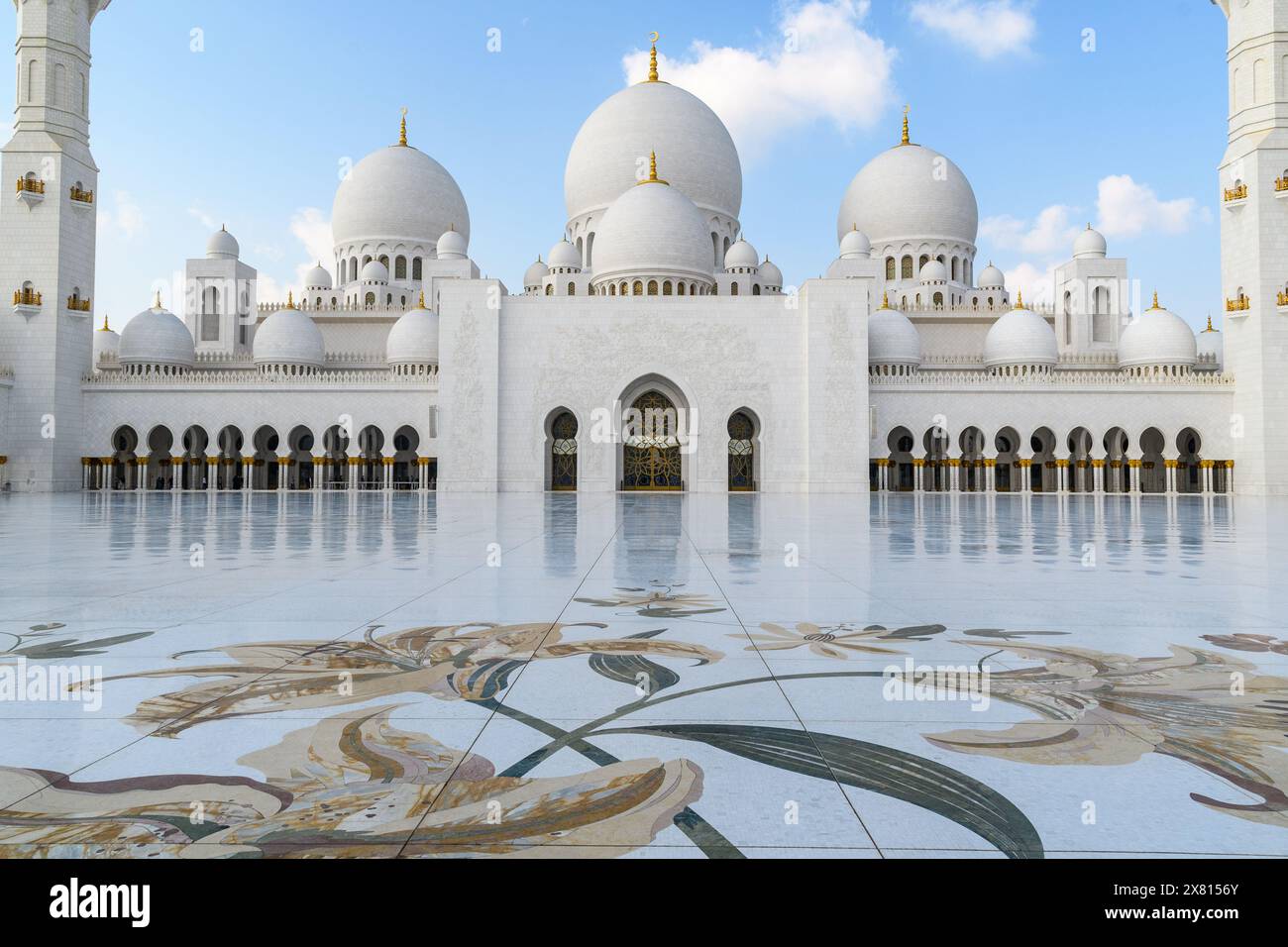 The majestic white marble domes of Abu Dhabi’s iconic mosque against a ...