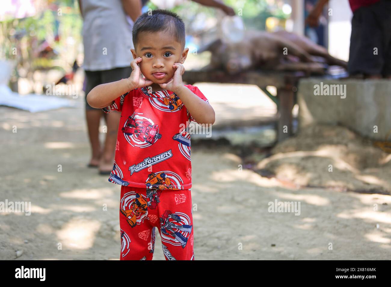 A young Filipino boy play with the camera by posing & asking for more ...
