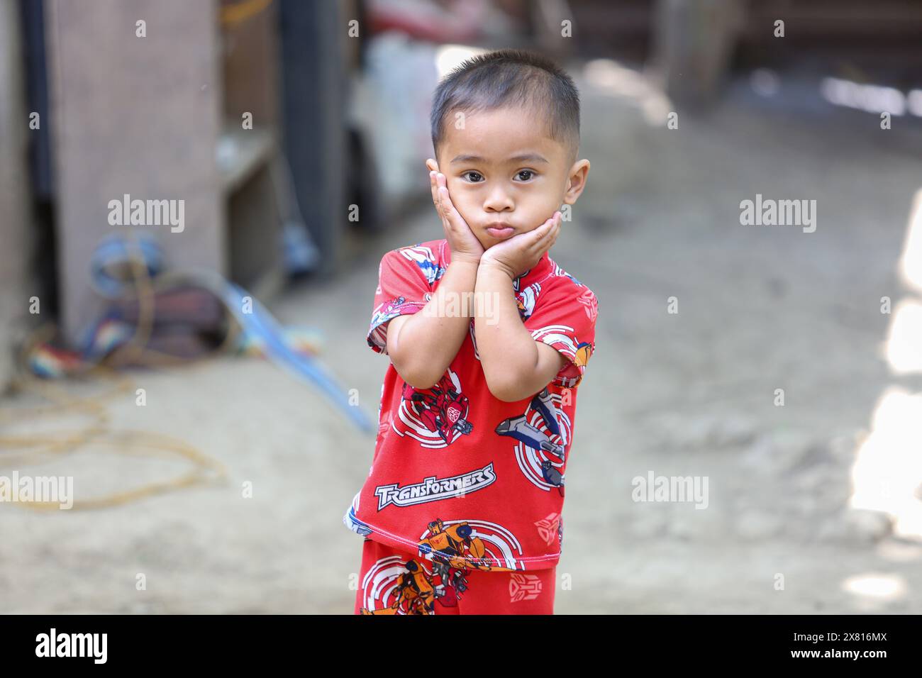 A young Filipino boy play with the camera by posing & asking for more ...