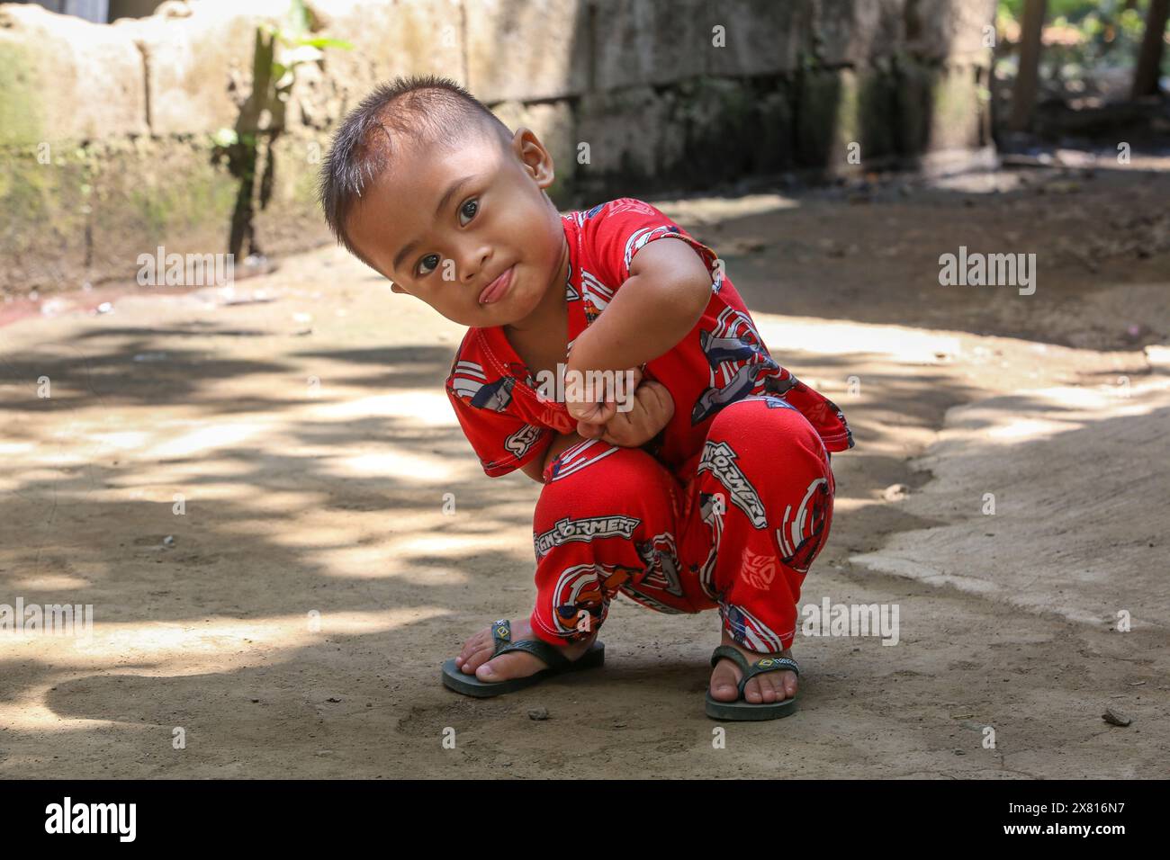A young Filipino boy play with the camera by posing & asking for more ...